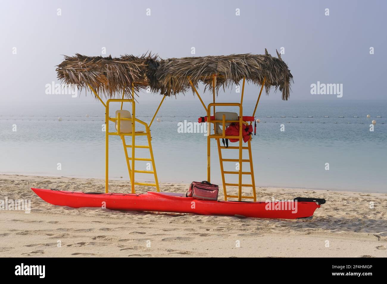 Empty yellow lifeguard towers with palm thatch roof and bright red ...