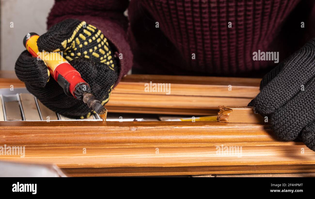 master to repair a defect on a wooden door using a wax pencil and a ...