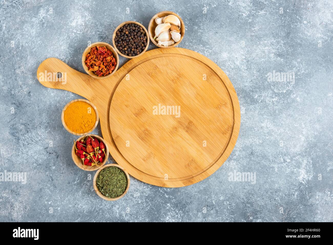 Small bowls of spices around wooden board Stock Photo - Alamy