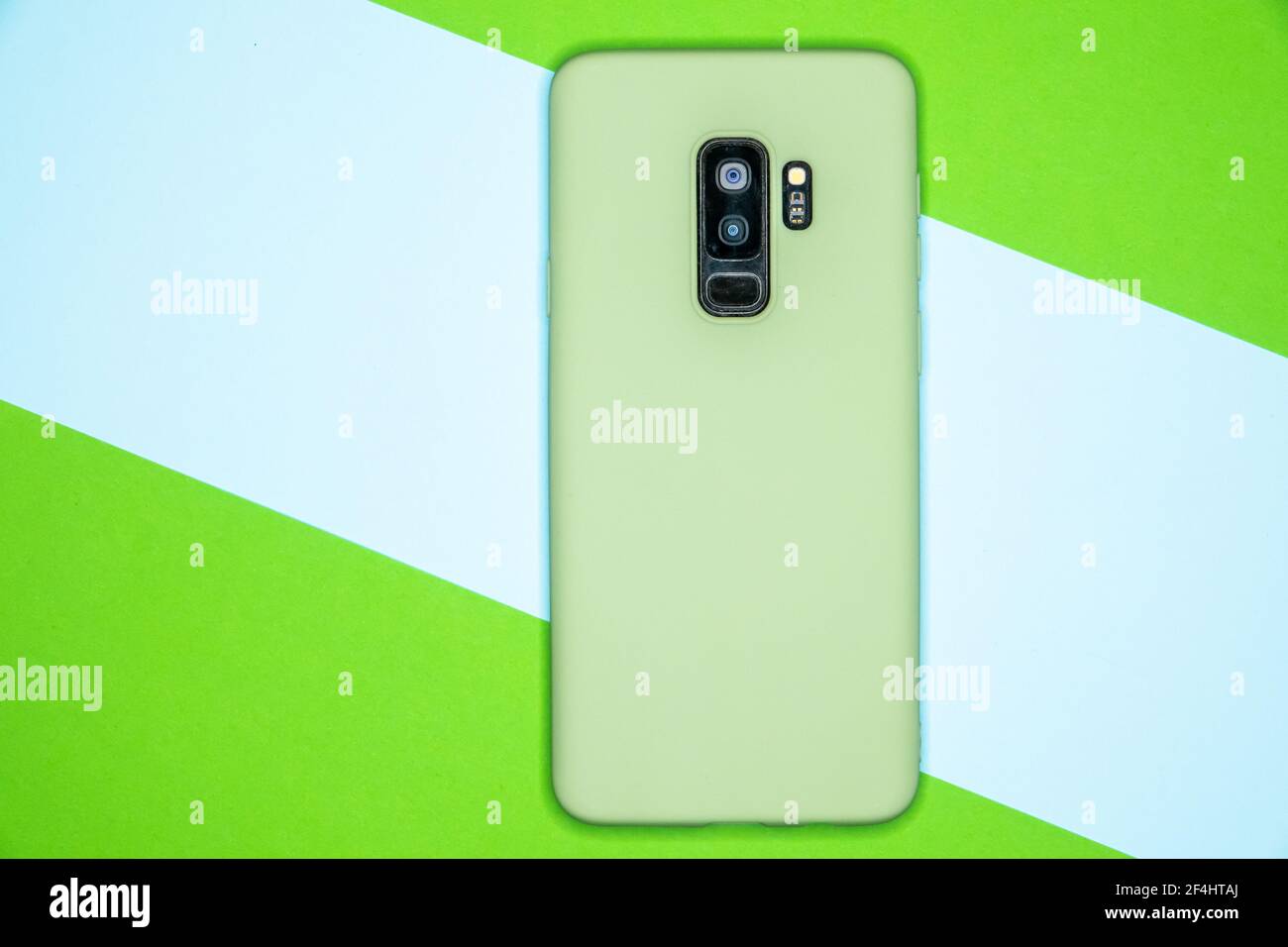 Modern light green mobile phone on a blue and green background Stock ...