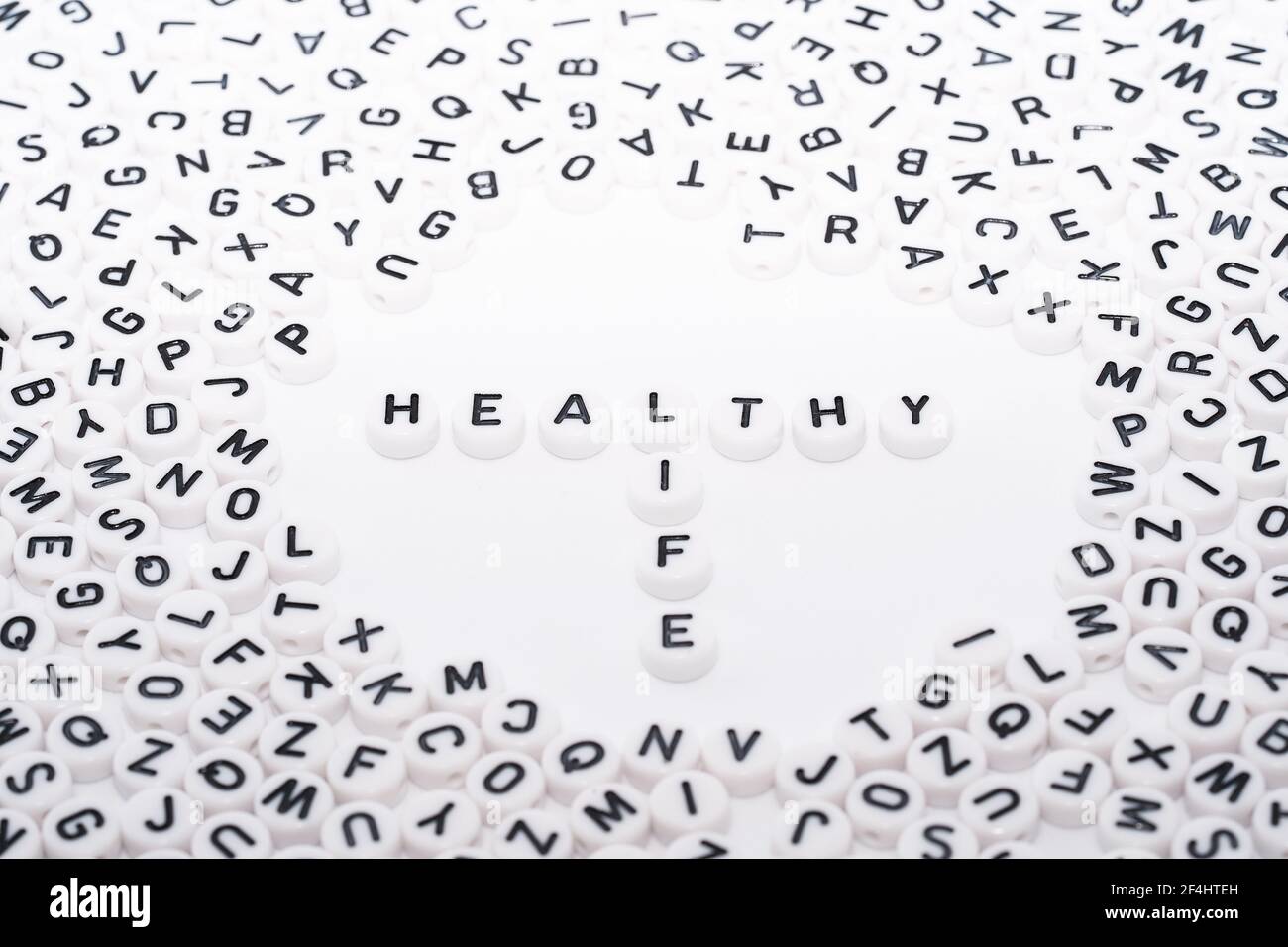 Healthy life letters on a block inside a sea of letters Stock Photo - Alamy