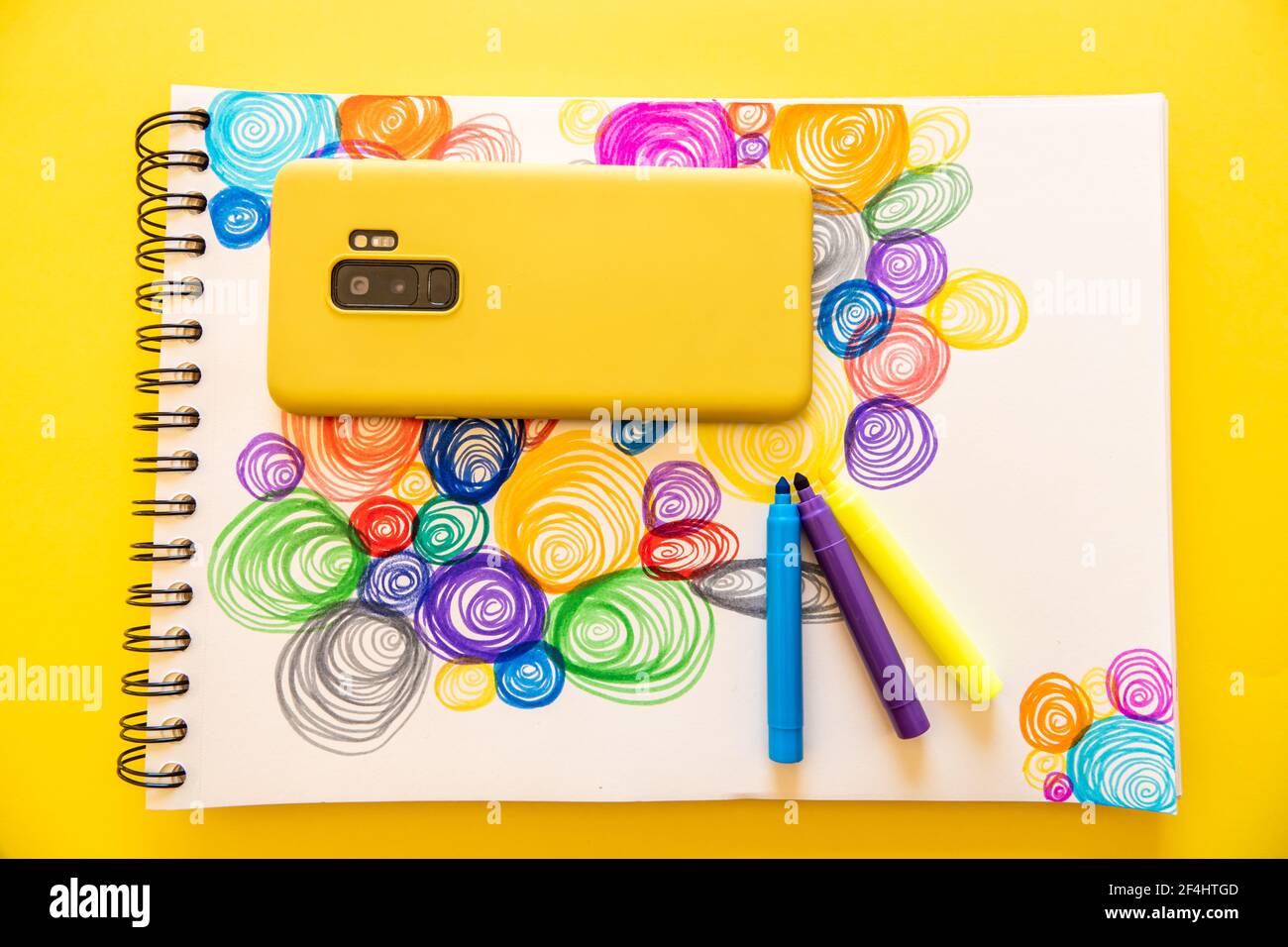 Top view of a modern yellow mobile phone on a drawing of colorful ...