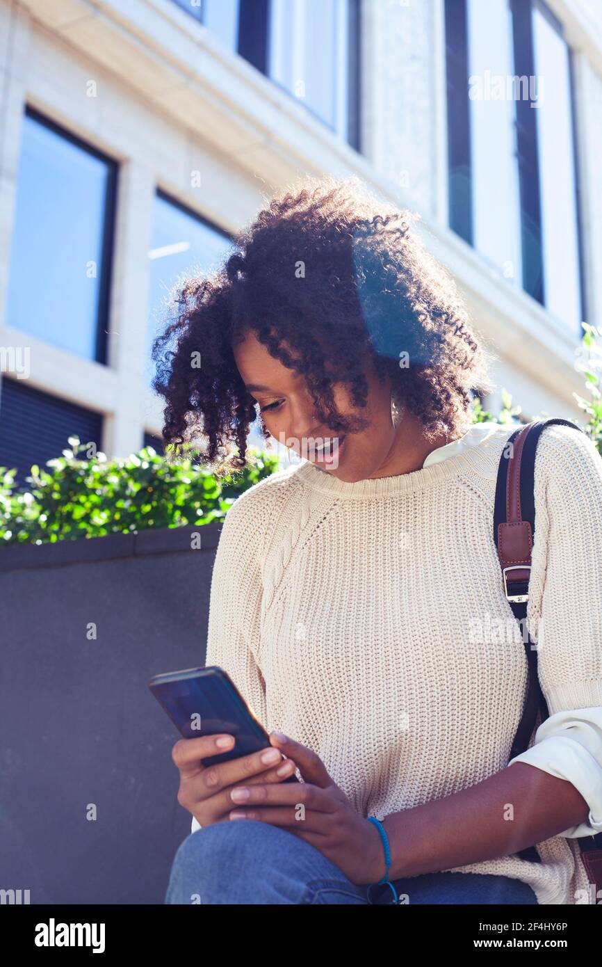 young pretty african girl posing cheerful on city background, lifestyle ...
