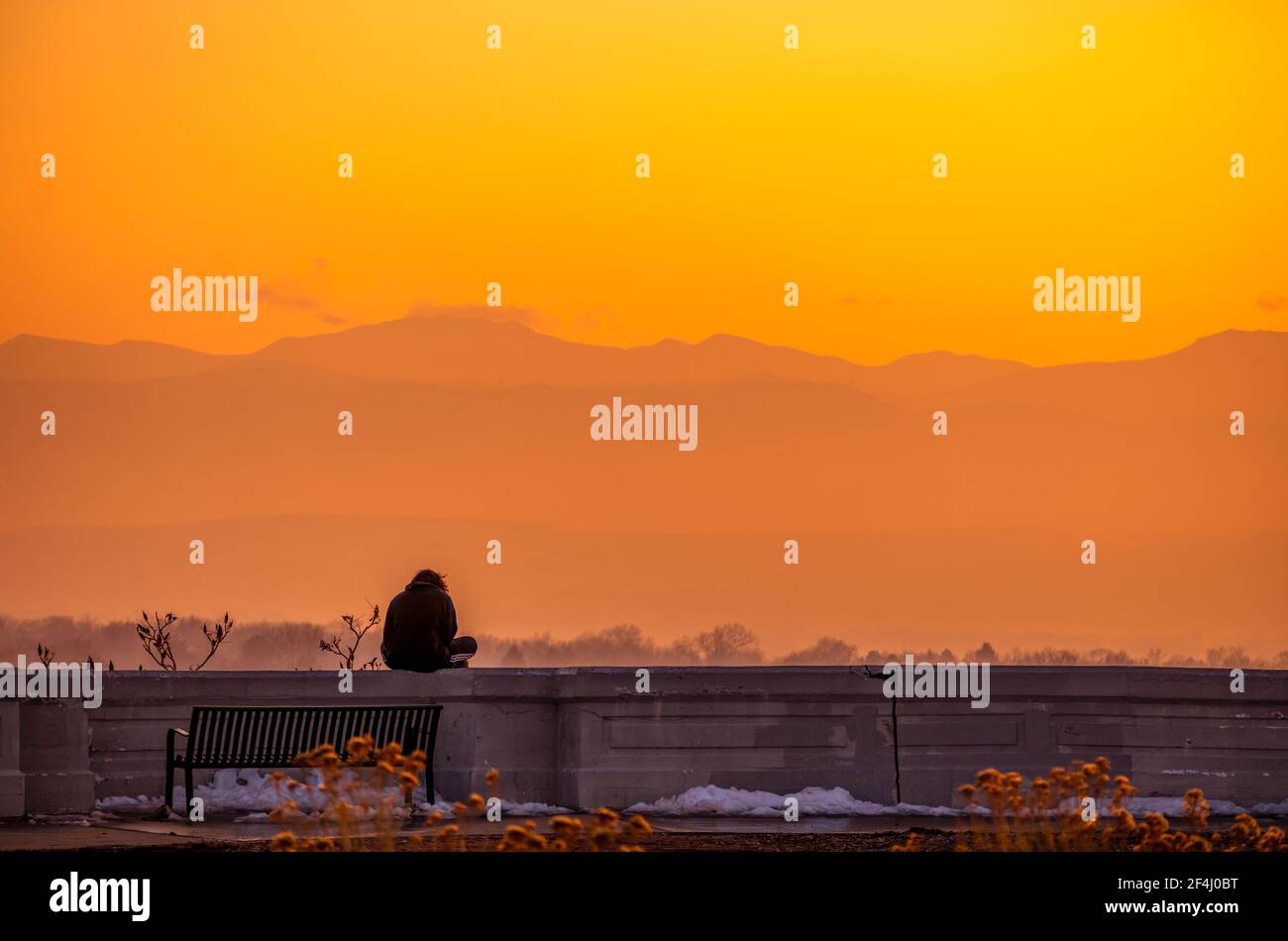 Back view of a person silhouette meditating at mountain sunset in the ...