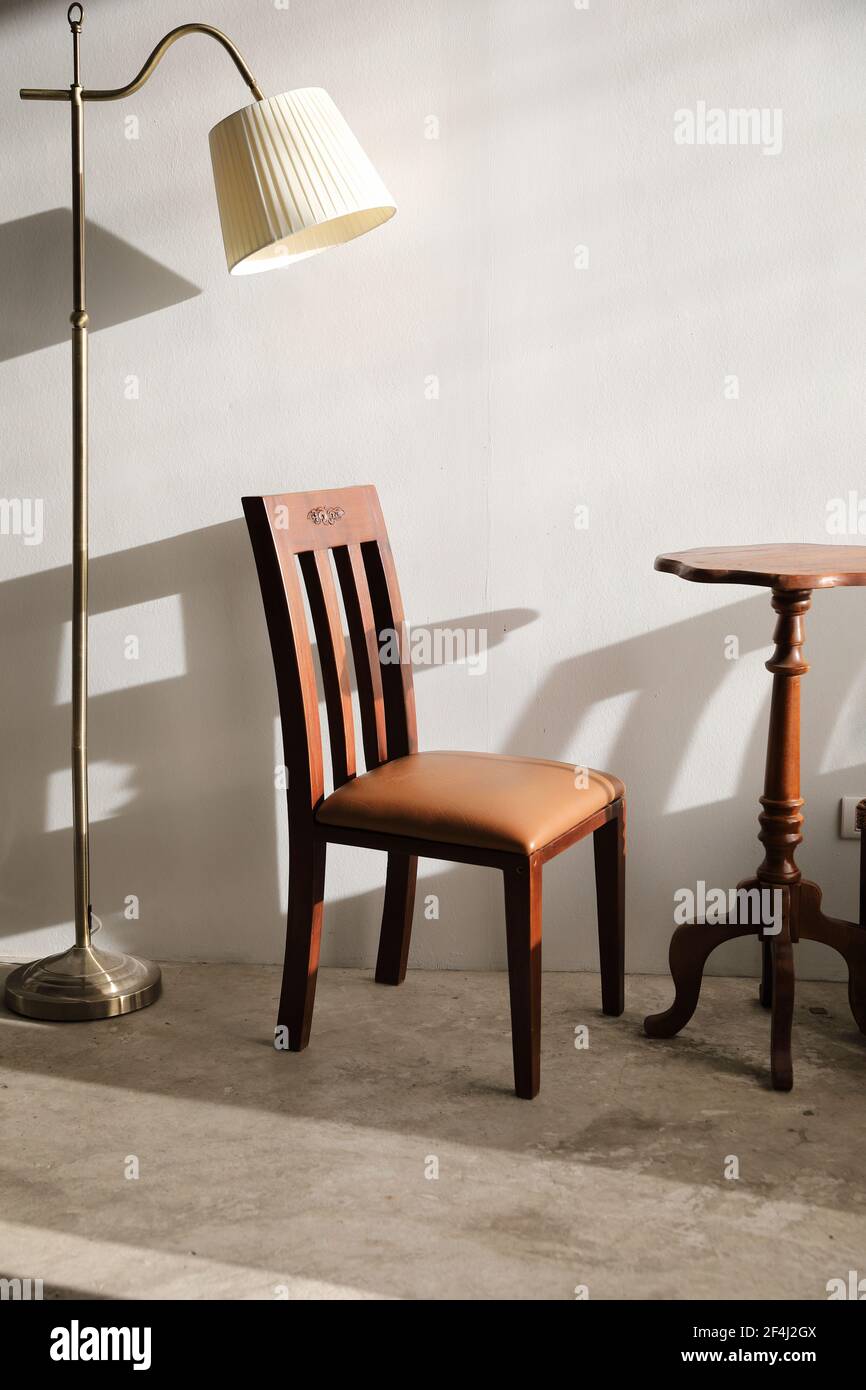 Wooden table and chairs with lamp on wall Stock Photo - Alamy