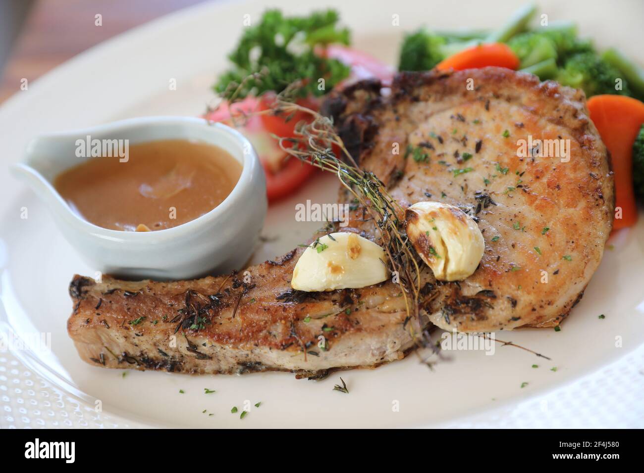 grilled pork chop with vegetable on dish with wood table background ...