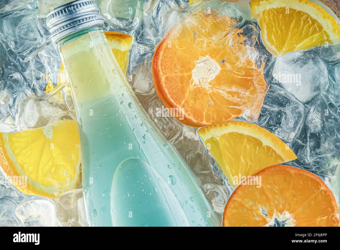 a bottle of green light green soda cocktail in cold water with ice ...