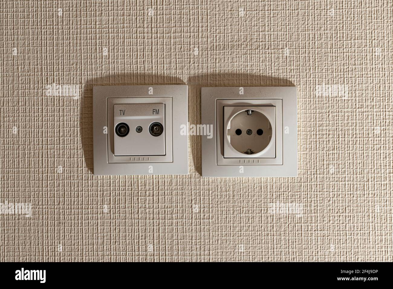 socket and socket for the TV antenna cable on the beige wall Stock ...