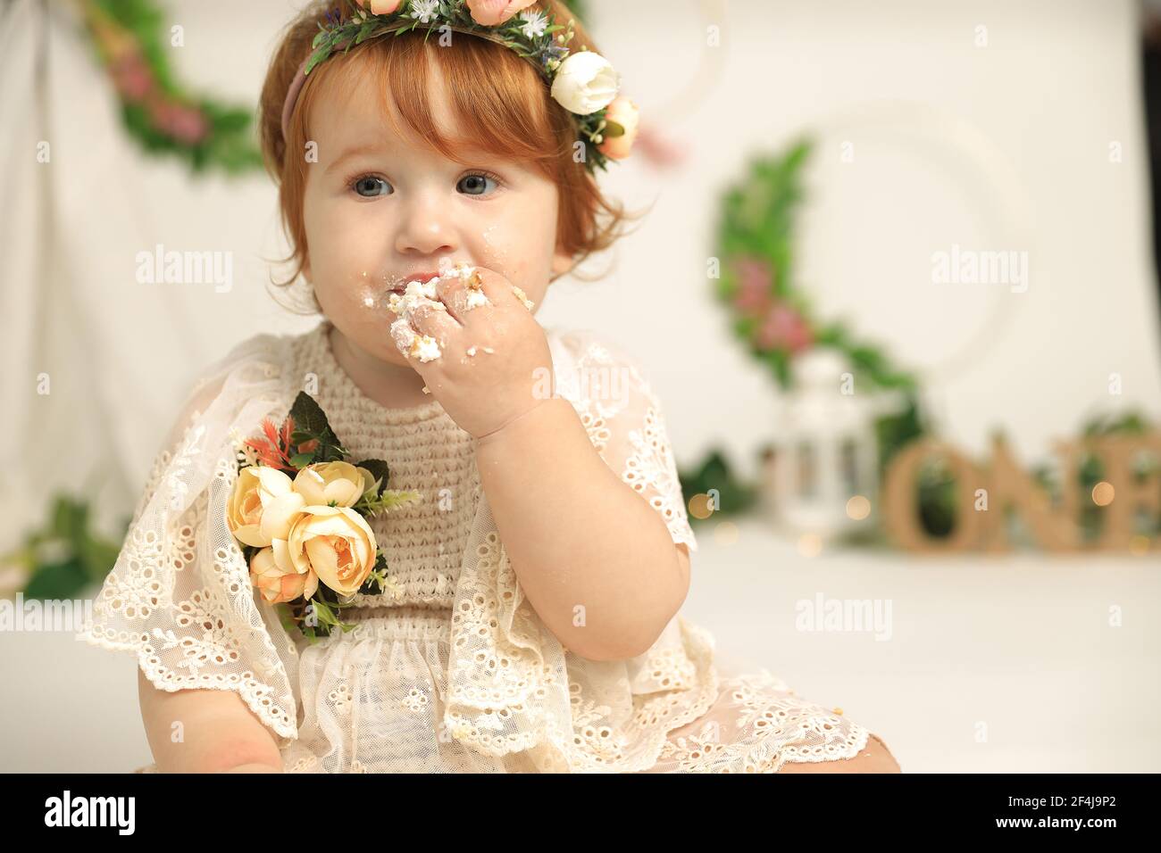 Portrait of a little birthday girl with the first cake. Eating the ...