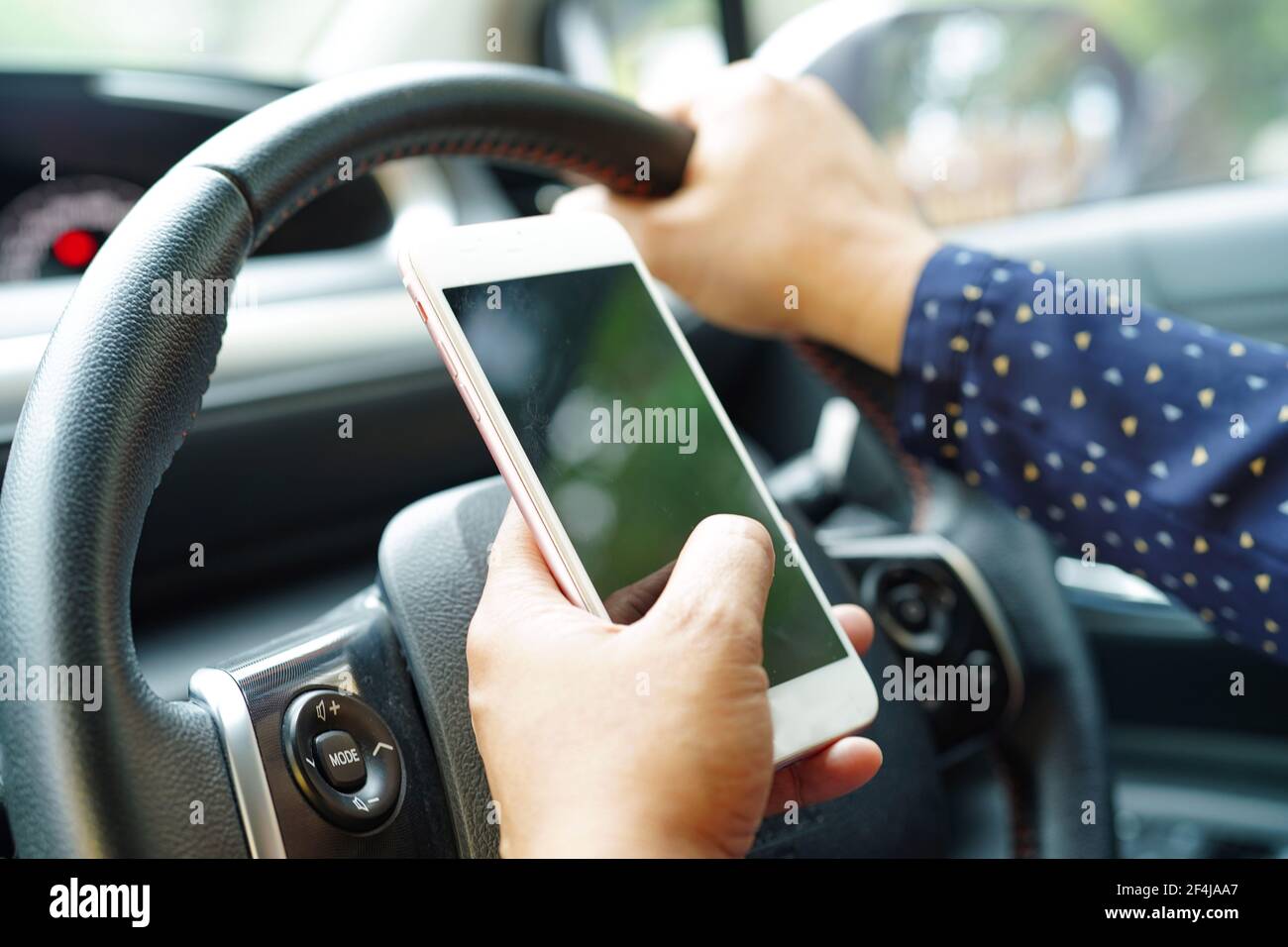 Holding mobile phone in car to communication with family and friends ...
