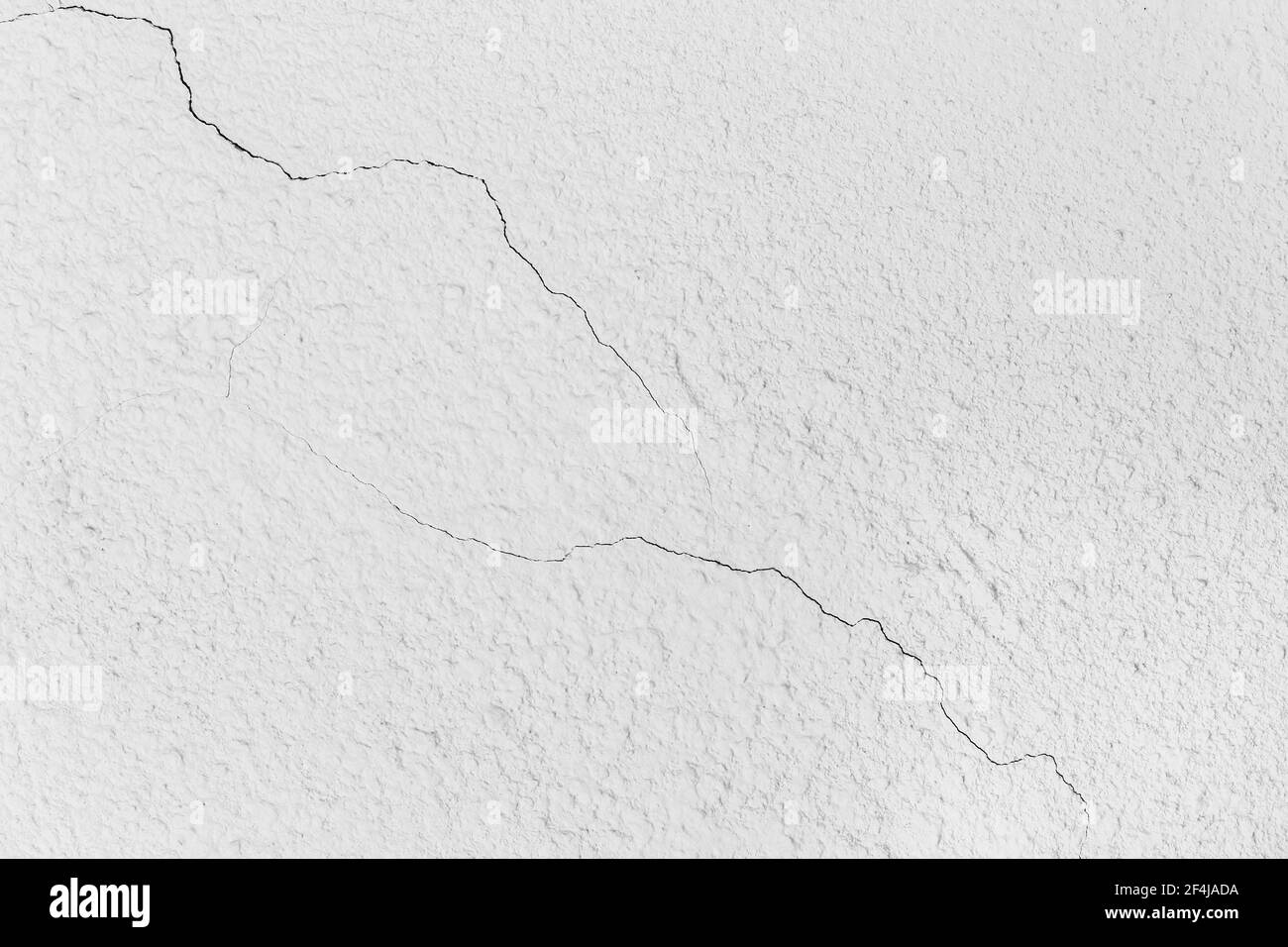 White concrete building wall with small cracks damaged texture ...
