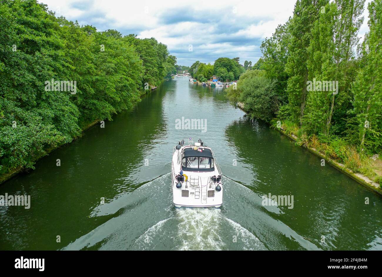 Motor boat travelling upstream on the River Thames through the ...