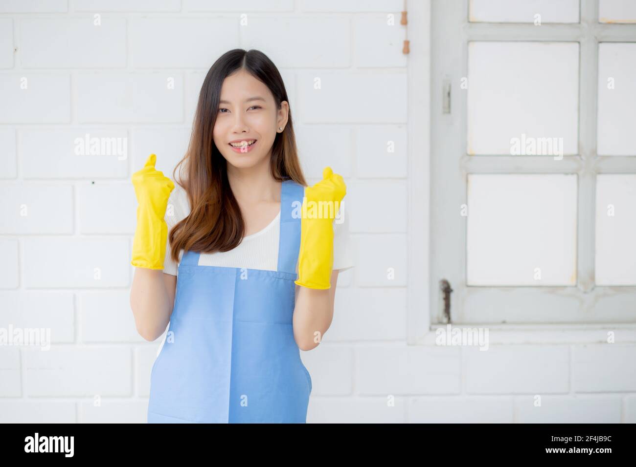 Portrait young asian woman is housekeeper in rubber gloves and apron ...