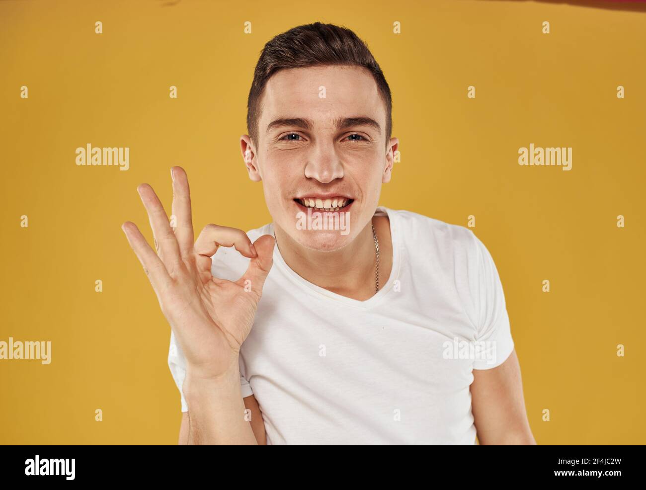 Man shows positive gestures with his hands fun yellow background ...