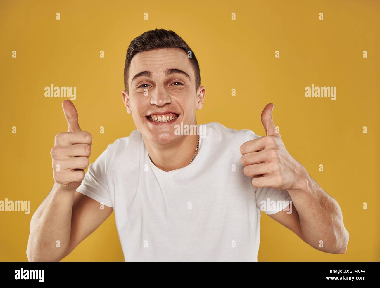 Man shows positive gestures with his hands fun yellow background ...