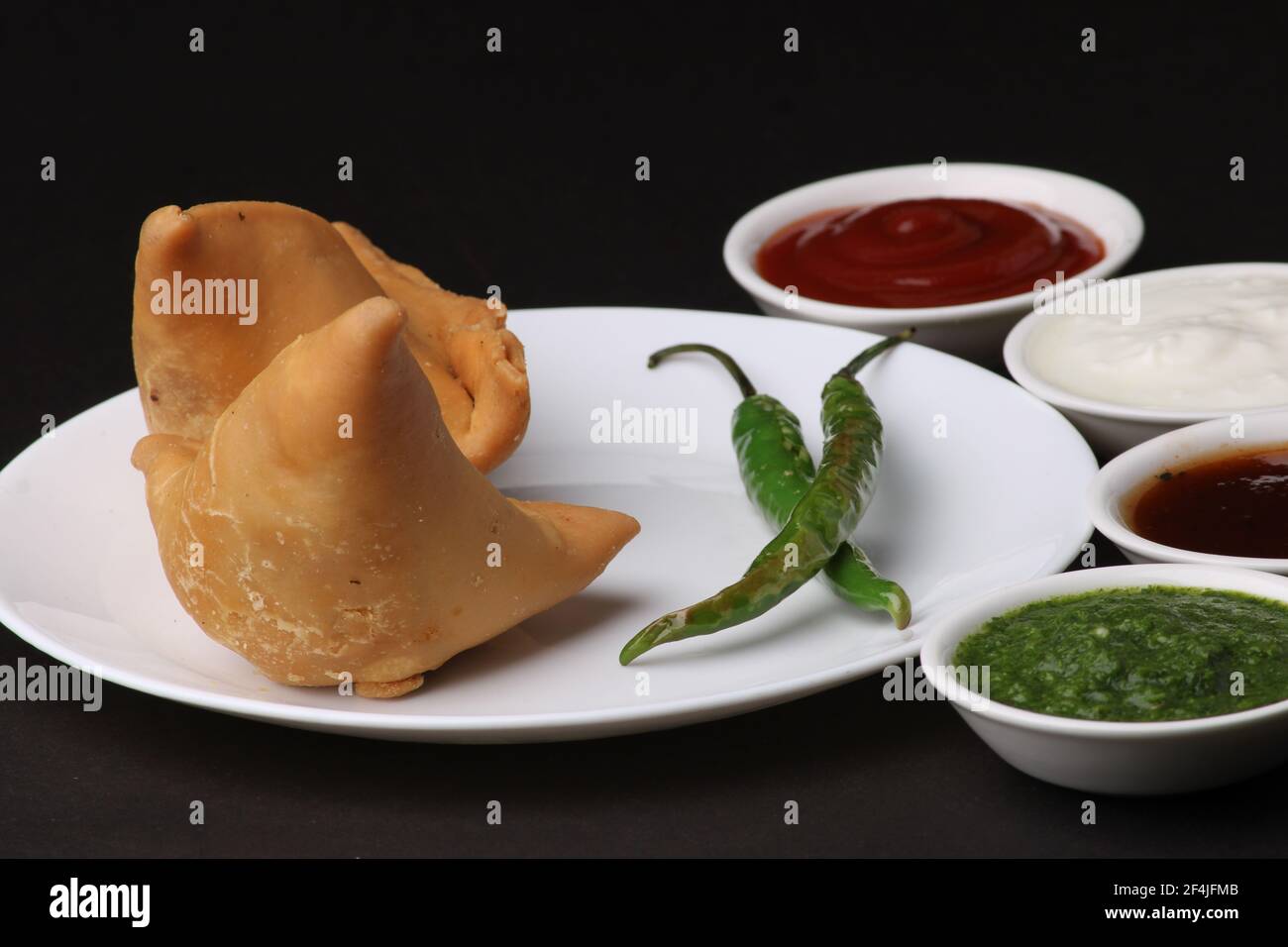 Indian snack Homemade spicy and delicious samosa served with green ...