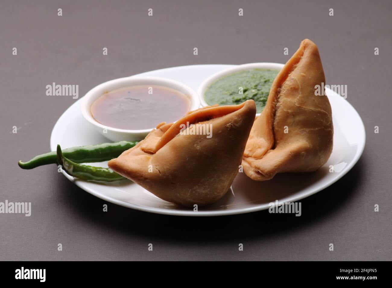 Indian snack Homemade spicy and delicious samosa served with green ...