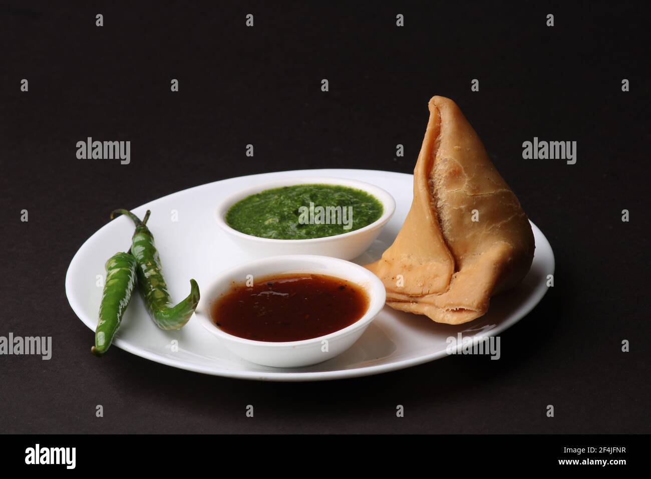 Indian snack Homemade spicy and delicious samosa served with green ...