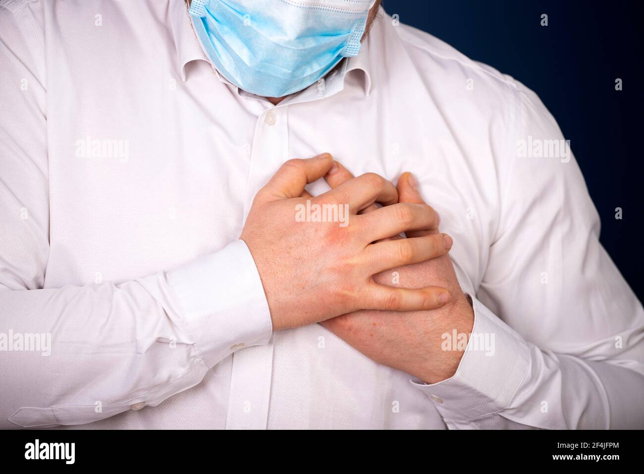 Man wearing medical face mask with chest pain - heart attack, shortness ...