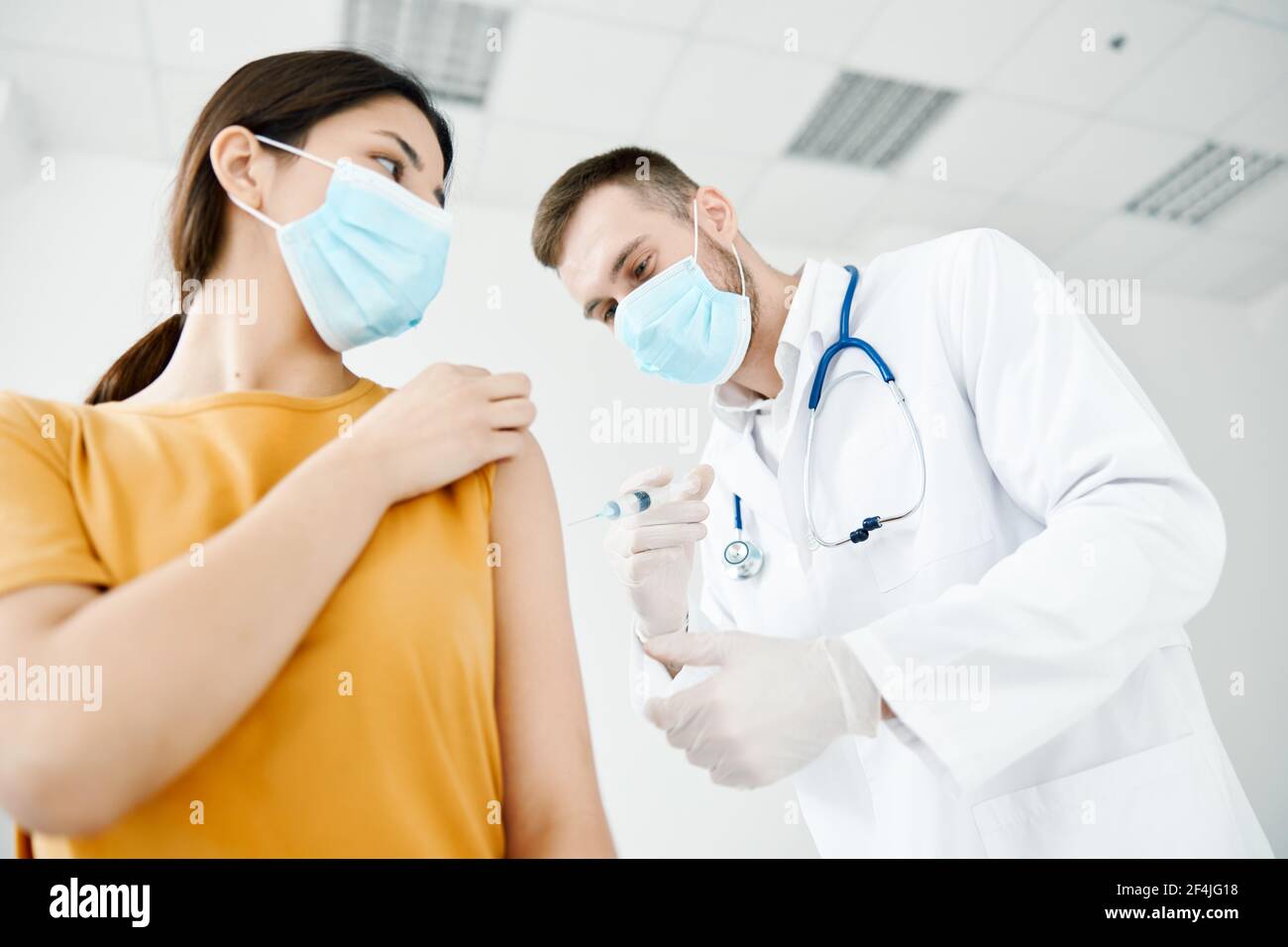 doctor makes an injection in the shoulder of a patient in a medical ...