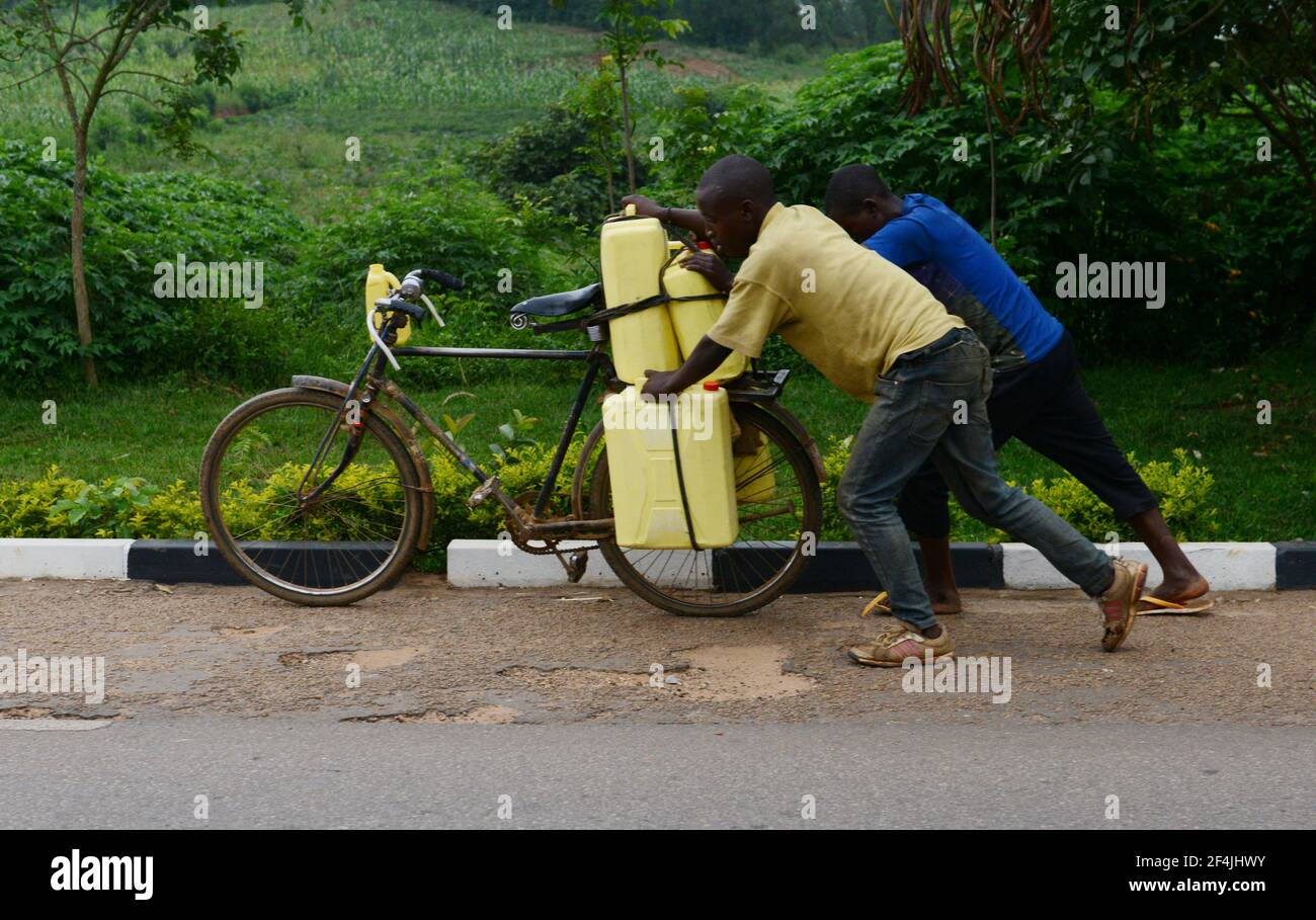 A Rwandan man pushing his loaded bicycle in rural Rwanda Stock Photo ...