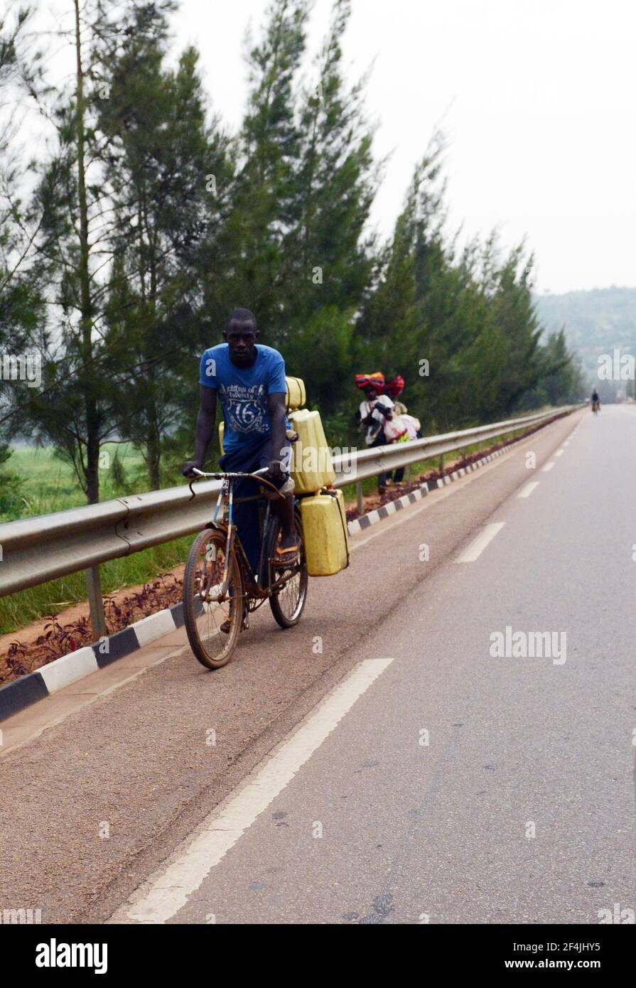 A Rwandan man pushing his loaded bicycle in rural Rwanda Stock Photo ...