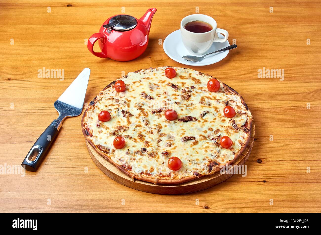 pizza Lombardy lies on a stand with tea and a kettle Stock Photo - Alamy