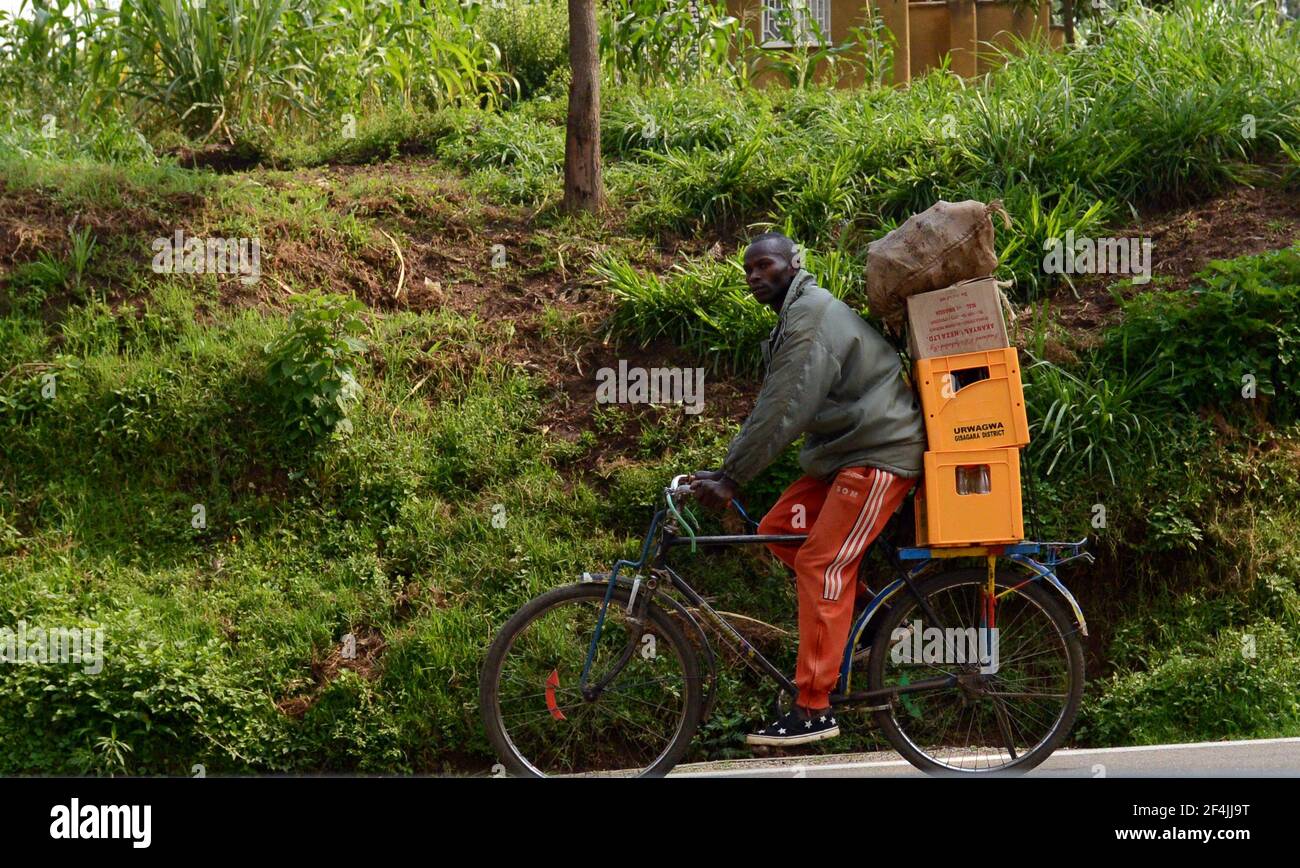 A Rwandan man pushing his loaded bicycle in rural Rwanda Stock Photo ...