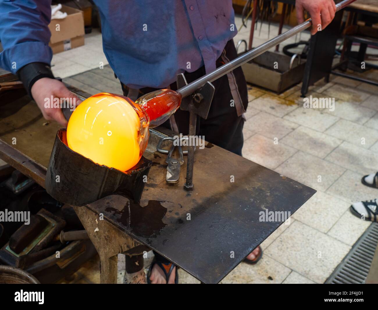 Glass blower forming beautiful piece of glass. A glass crafter is ...