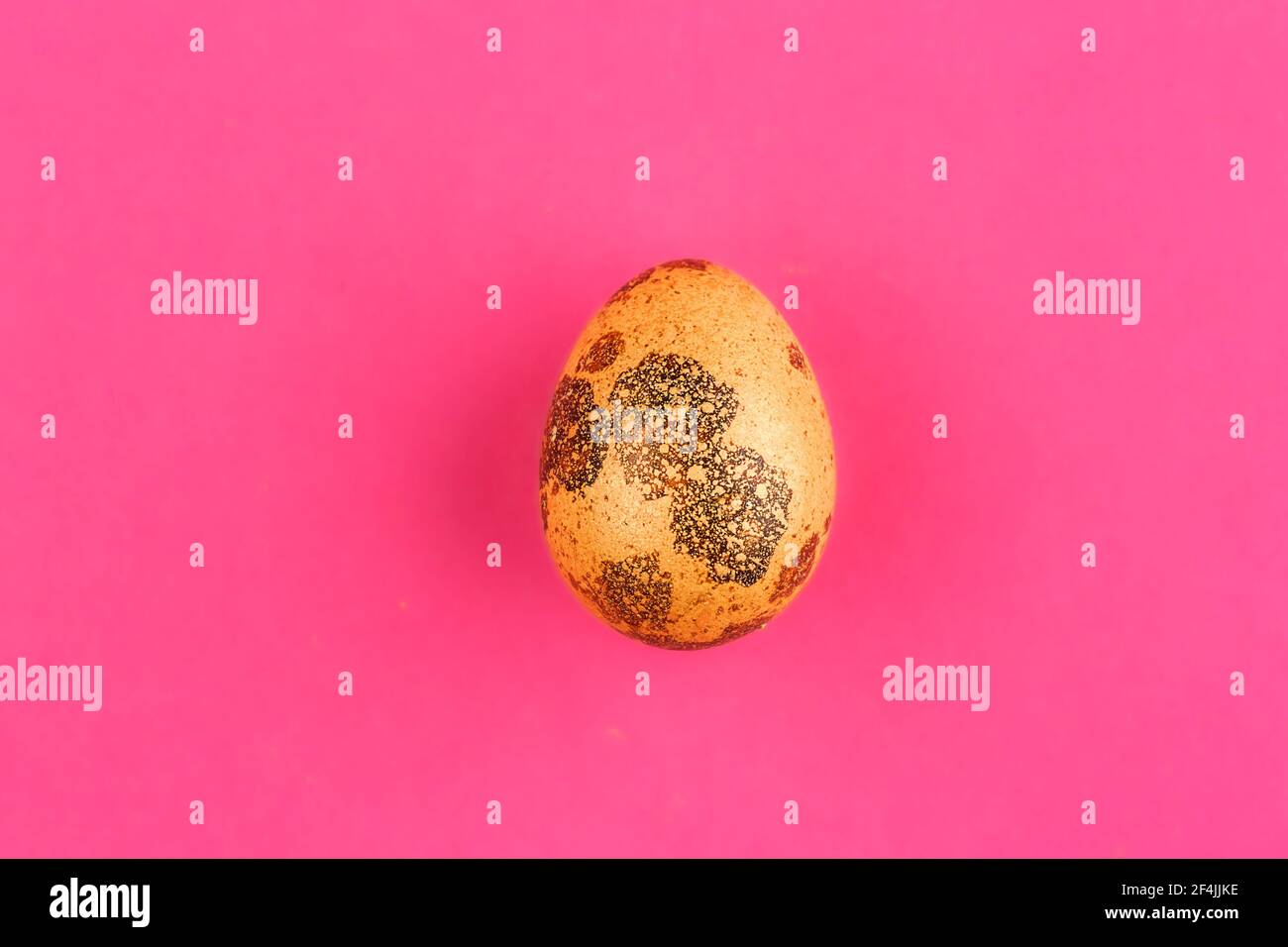 Easter egg painted orange with gold. One painted easter egg on a pink ...