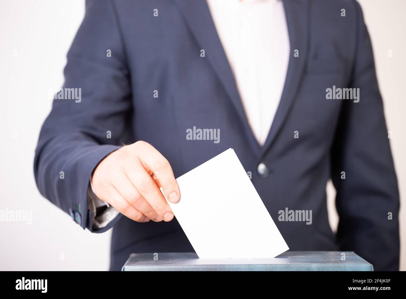 Hand of a voter putting vote in the ballot box. Election concept Stock ...