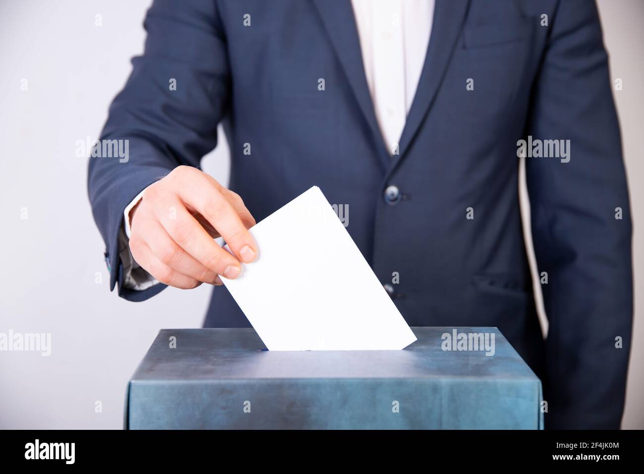 Hand of a voter putting vote in the ballot box. Election concept Stock ...