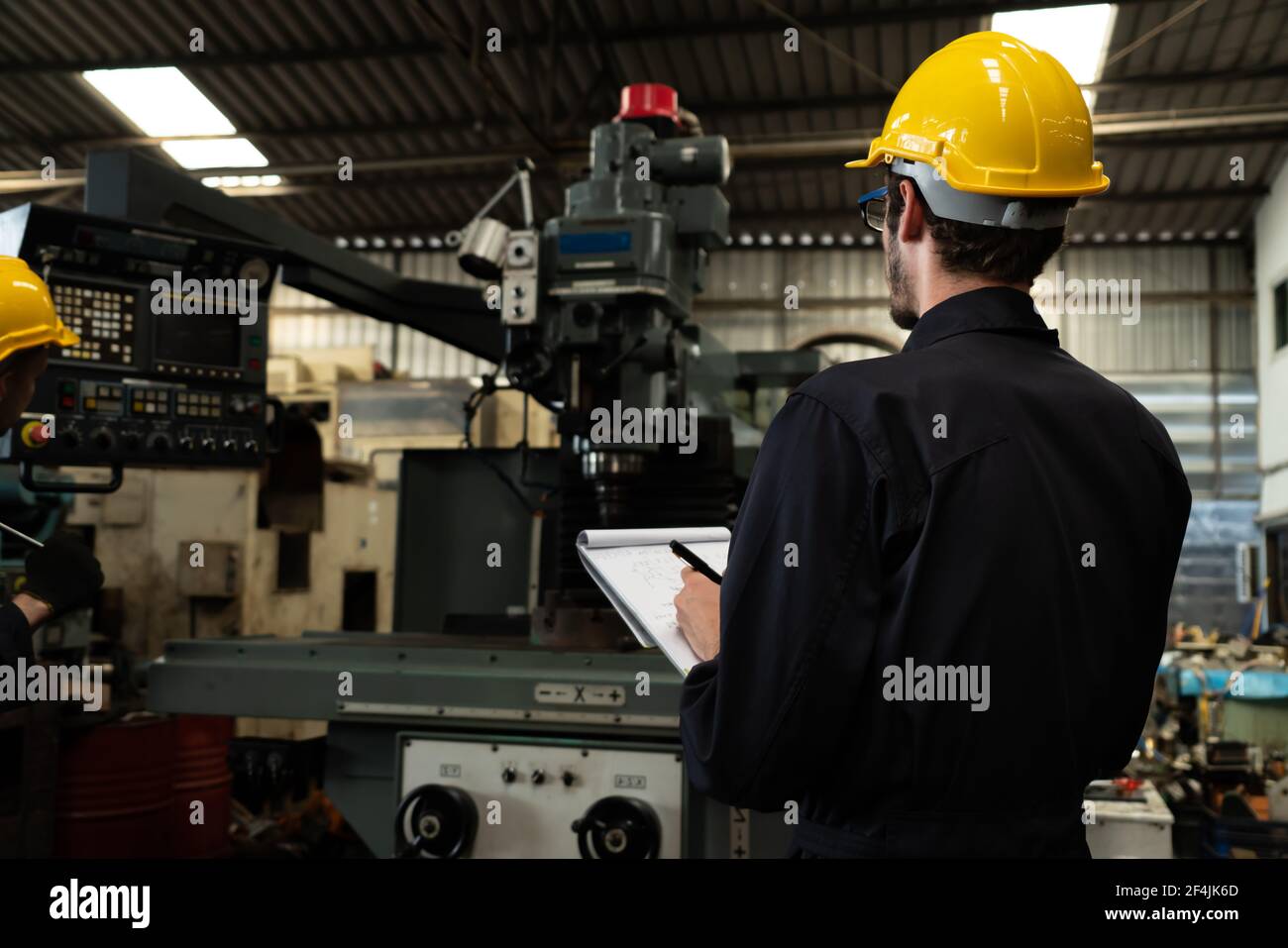 Skillful factory worker working with clipboard to do job procedure ...