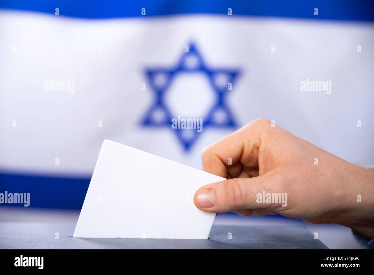 Election in Israel. Hand of voter putting vote in the ballot box. Waved ...