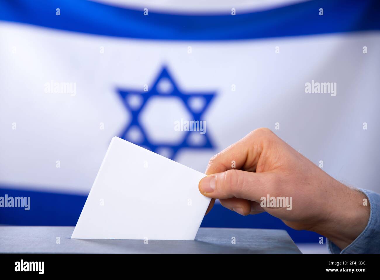 Election in Israel. Hand of voter putting vote in the ballot box. Waved ...