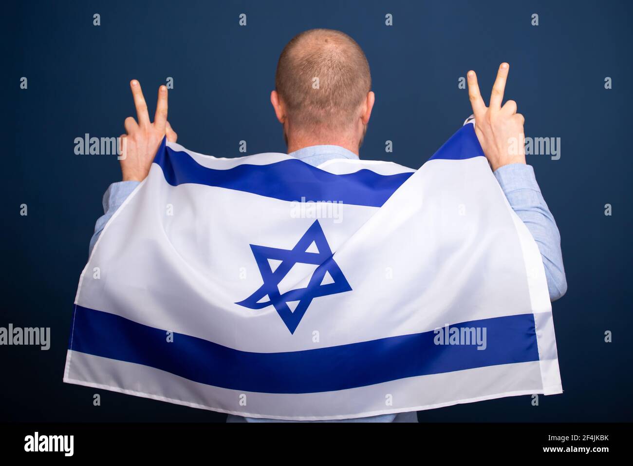 Israeli patriot holding the flag of Israel on his shoulders Stock Photo ...