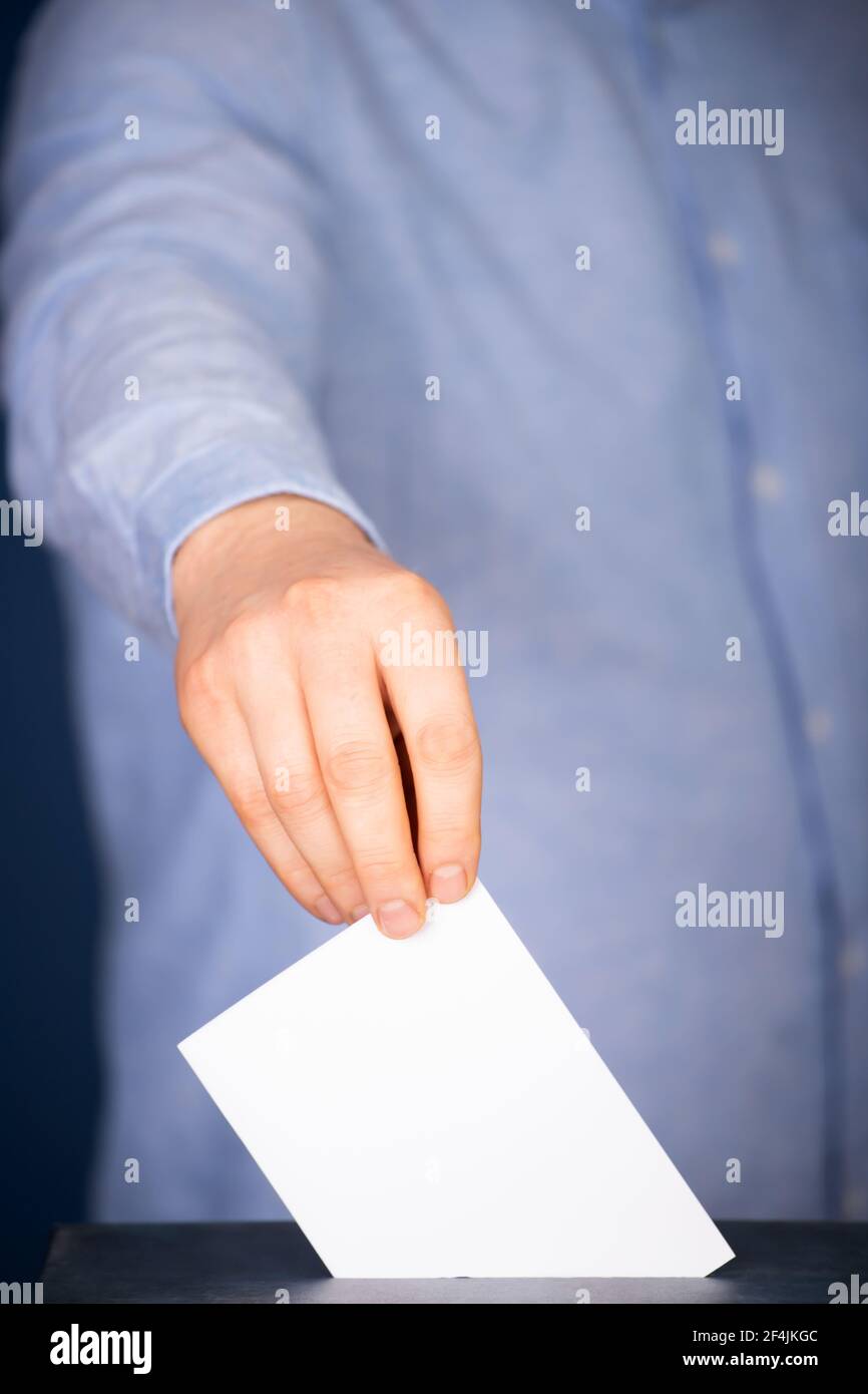 Hand of a voter putting vote in the ballot box. Election concept Stock ...