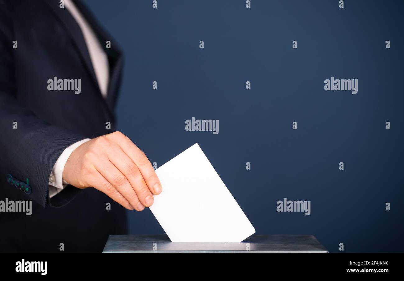 Hand of a voter putting vote in the ballot box. Election concept Stock ...