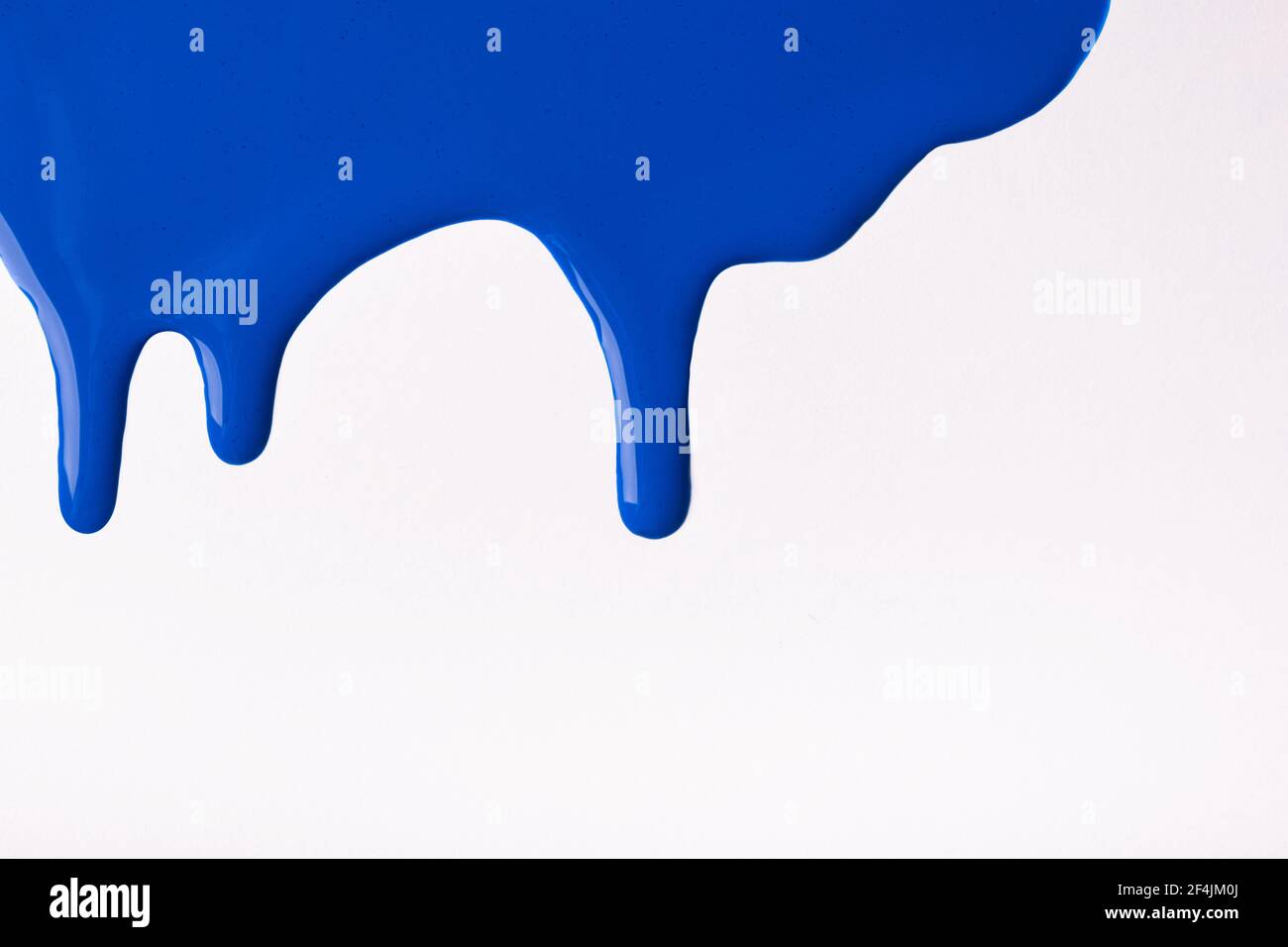 Navy blue liquid drops of paint color flow down on isolated white ...