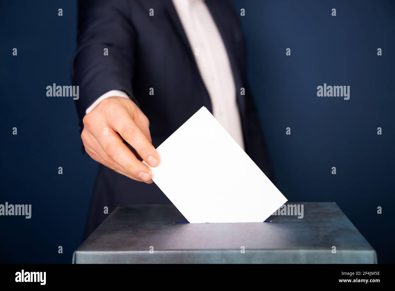 Hand of a voter putting vote in the ballot box. Election concept Stock ...