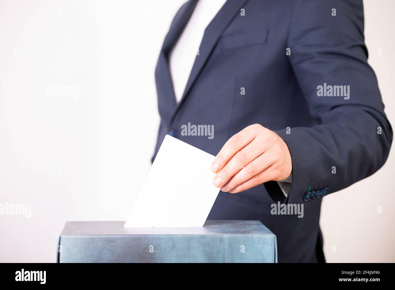 Hand of a voter putting vote in the ballot box. Election concept Stock ...