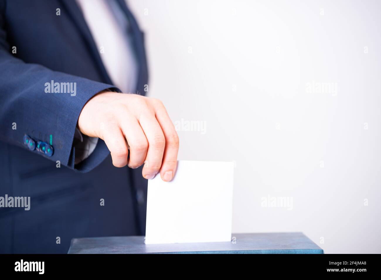 Hand of a voter putting vote in the ballot box. Election concept Stock ...