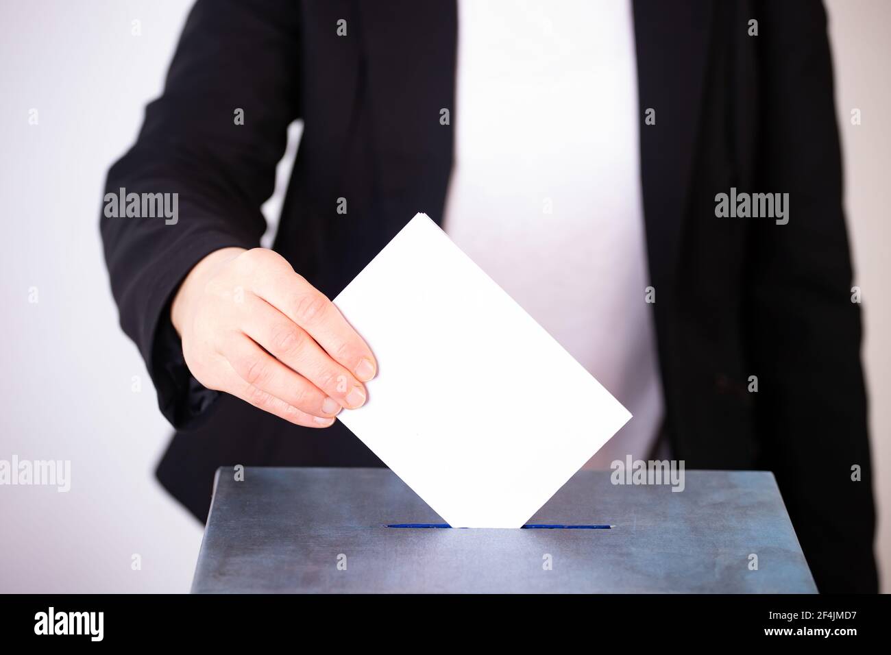 Hand of a voter putting vote in the ballot box. Election concept Stock ...