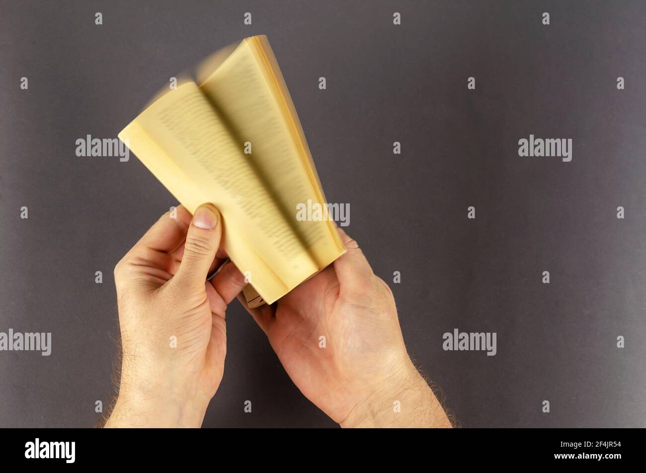 Blurred Motion Of Hand Turning Page Over gray Background. Male hands ...