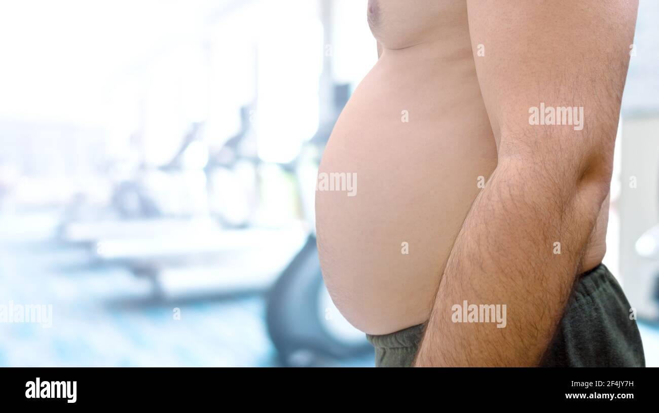 Obese man with excessive belly fat on gym background. Sports lifestyle ...