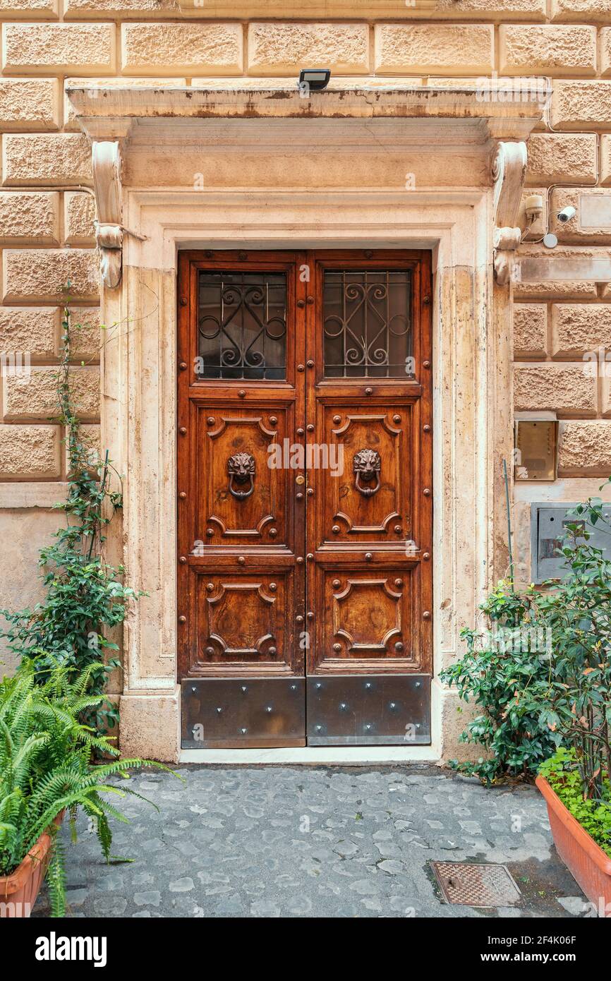 Ancient beautiful wooden door with door knockers and porch decorated ...