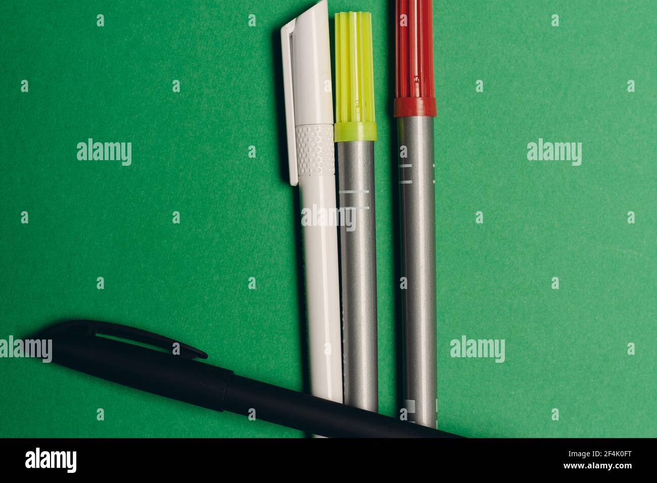 multicolored pens on a green background office supplies work stationery ...