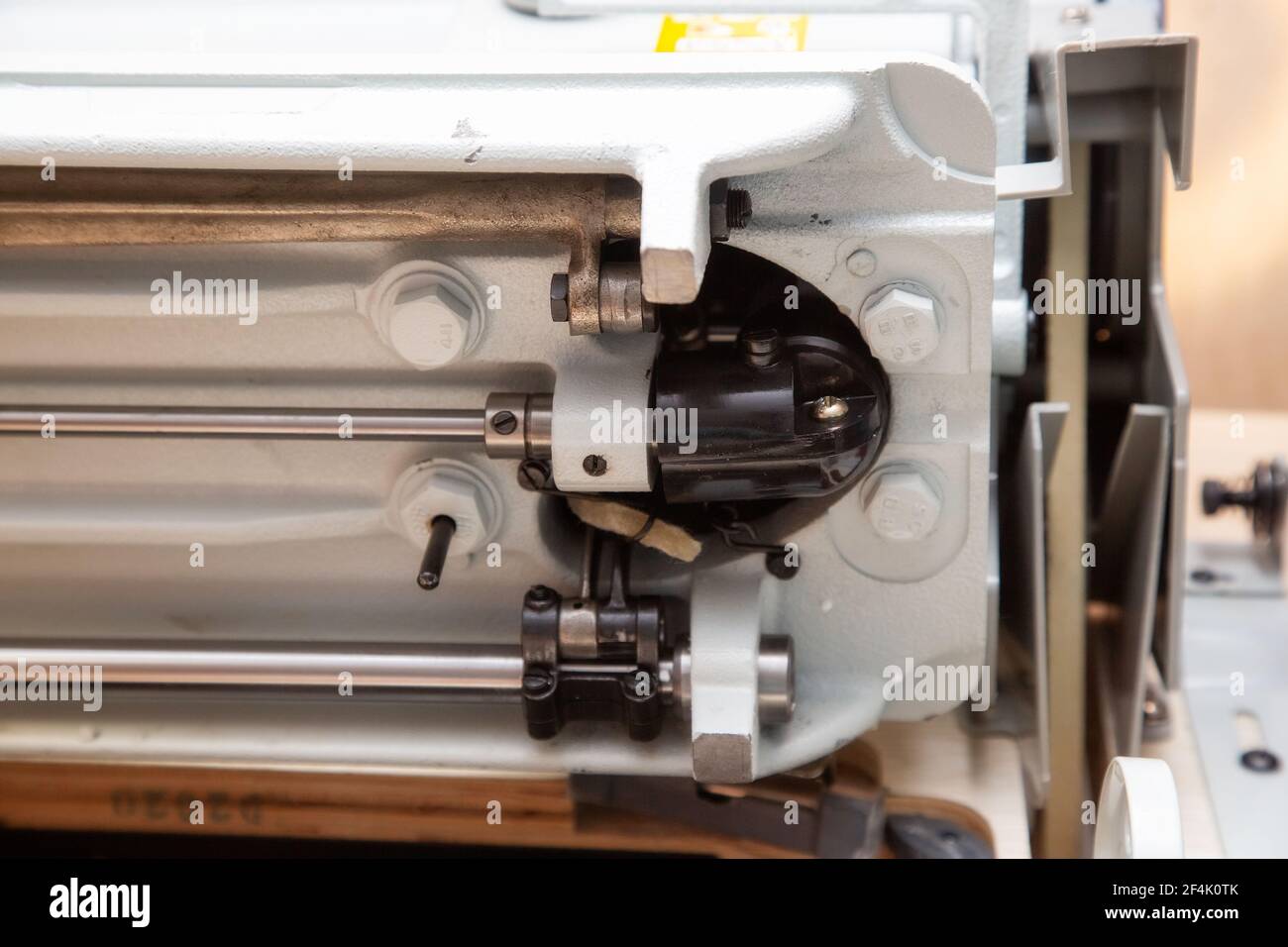 Parts and components of an industrial sewing machine tilted to one side ...