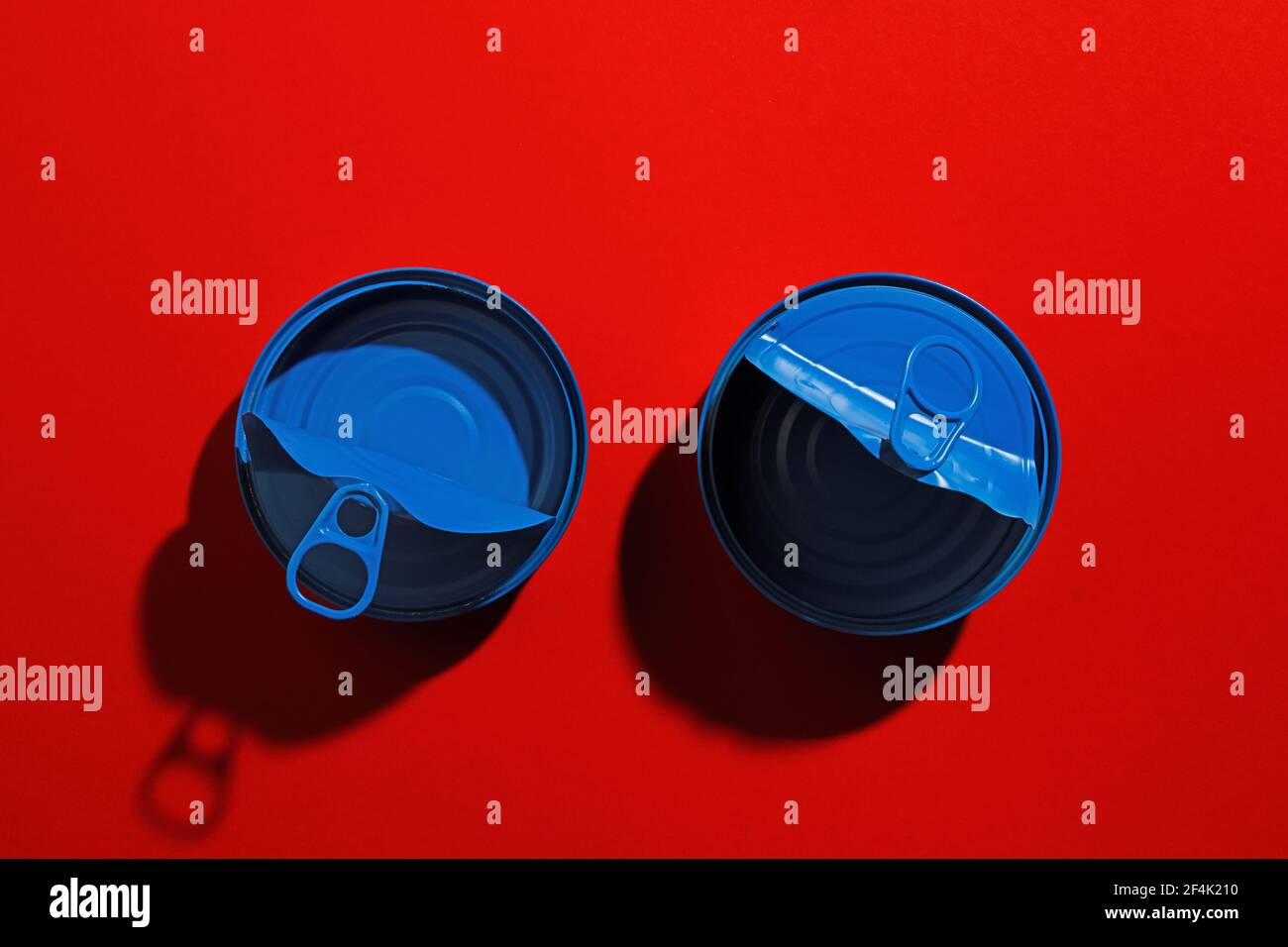 Blue tin can on dark red background Stock Photo - Alamy