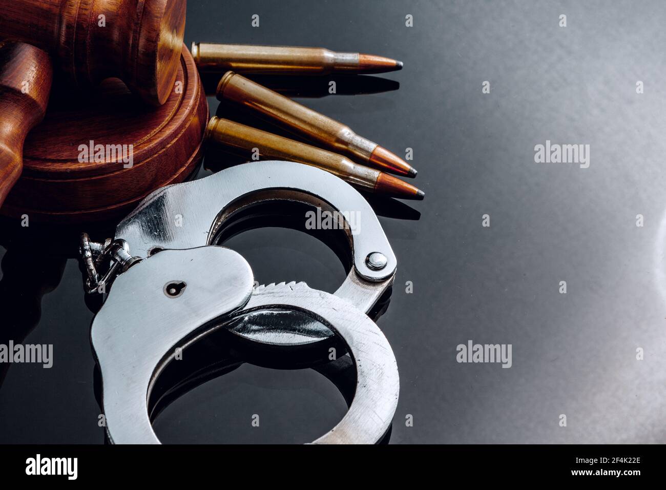 Handcuffs and rifle bullets on black background Stock Photo - Alamy